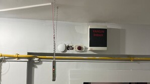 Uma porta branca com um detector de incêndio e uma placa com a inscrição