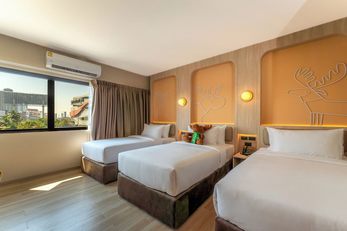 Quarto de hotel com duas camas, uma janela grande e vista para o horizonte urbano.