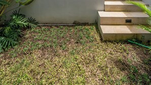 Uma casa moderna com uma ampla janela de vidro, piscina e escadaria que leva à entrada.