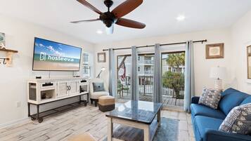 Condo com design assinado, 2 quartos, sacada, vista para a piscina | Sala de estar | Smart TV 65 polegadas com canais a cabo