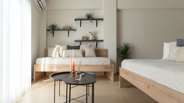 Quarto moderno com cama, mesas de cabeceira e prateleiras fixadas na parede.