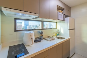 Uma cozinha moderna com fogão embutido, micro-ondas e geladeira.