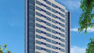 Um edifício moderno e imponente com uma fachada de janelas em grade e um céu claro.