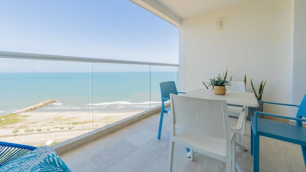 Uma varanda com vista para a praia e o oceano.