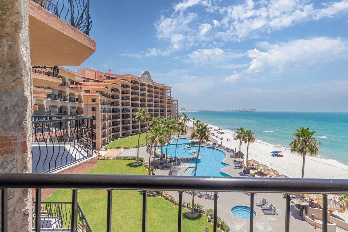 Resort com piscina, praia e vista para o oceano.