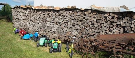 Uma fileira de carros de brinquedo coloridos estacionados em frente a um muro de pedra.