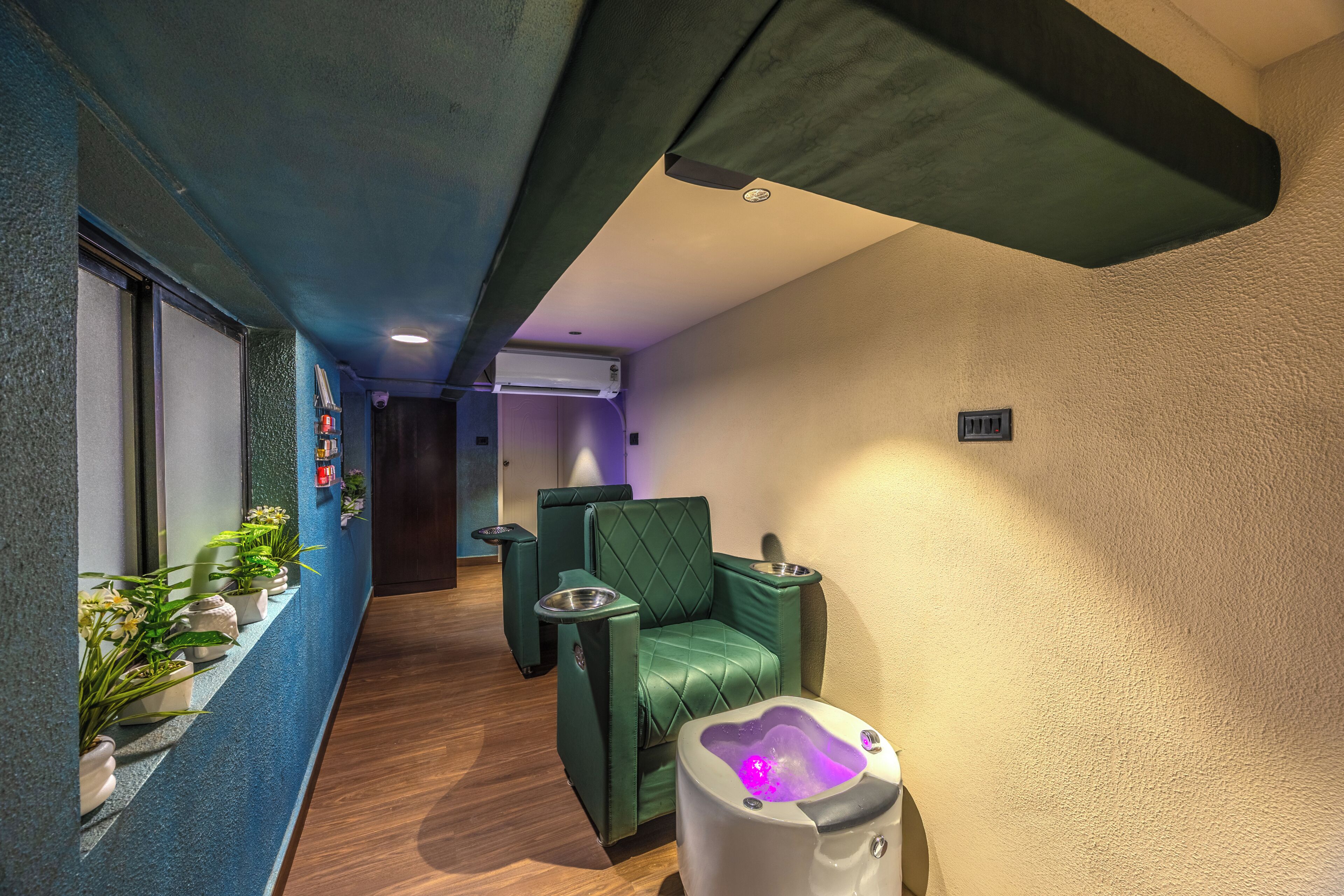 Uma área de spa com cadeira de massagem, hidromassagem e janela com plantas.