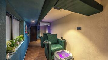Uma área de spa com cadeira de massagem, hidromassagem e janela com plantas.