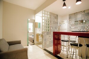 Uma cozinha moderna com bancada vermelha, banquetas e painel de fundo padronizado.