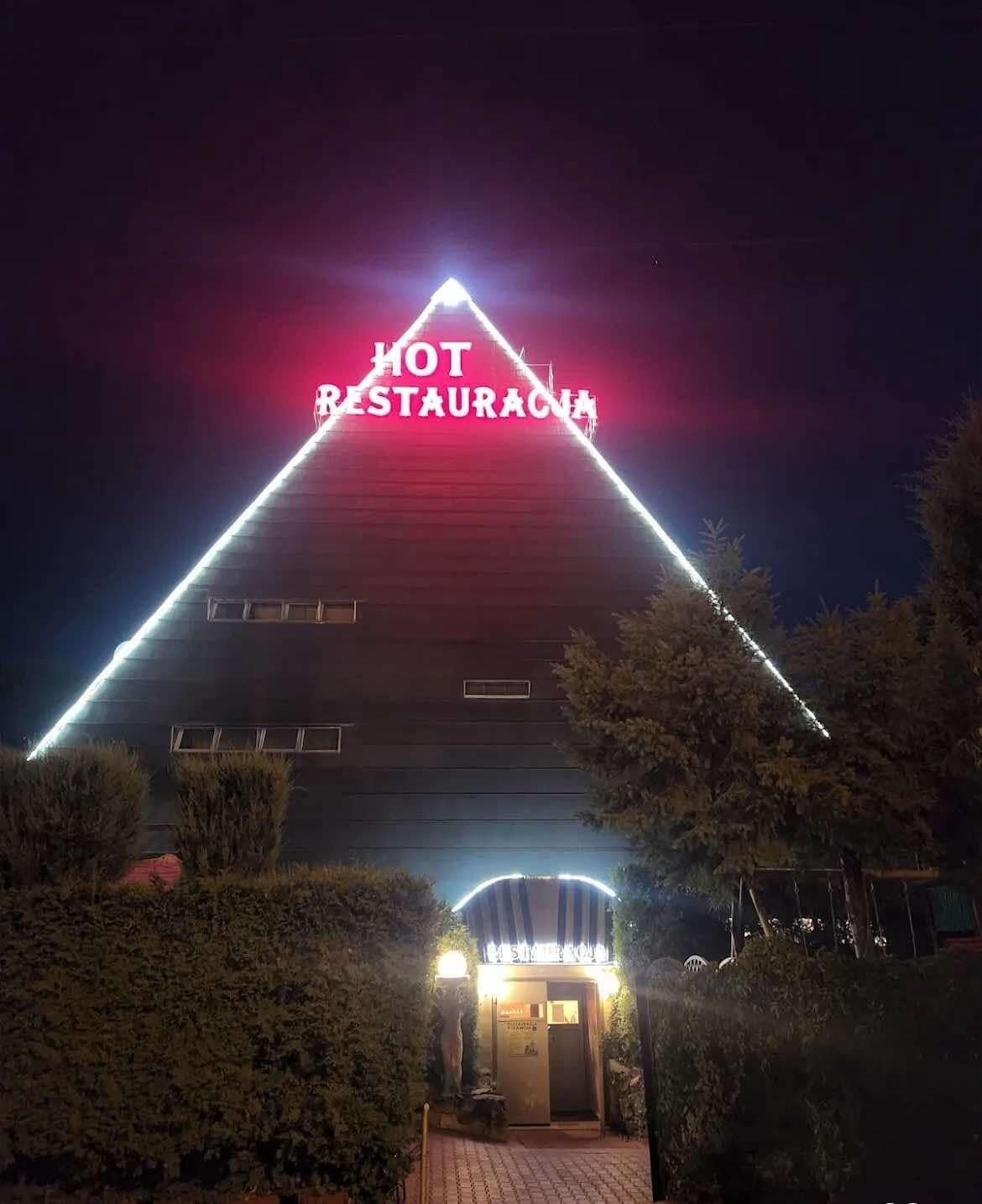 Um edifício com estrutura de telhado triangular e uma placa que diz 'HOT RESTAURANT'.