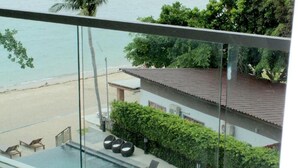 Uma varanda com vista para uma praia e um edifício com telhado de azulejos.
