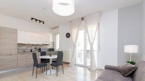 Apartamento moderno com sala de jantar, cozinha e sala de estar.