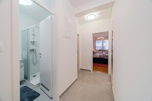 Apartamento Familiar, 1 quarto (Modern Oasis With Terrace) | Casa de banho | Um polibã, um secador de cabelo, toalhas fornecidas, sabão