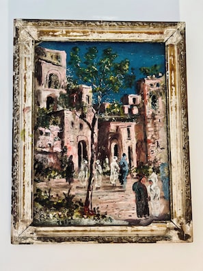 Pintura de um edifício antigo com arcos e ruínas, emoldurada e pendurada na parede.