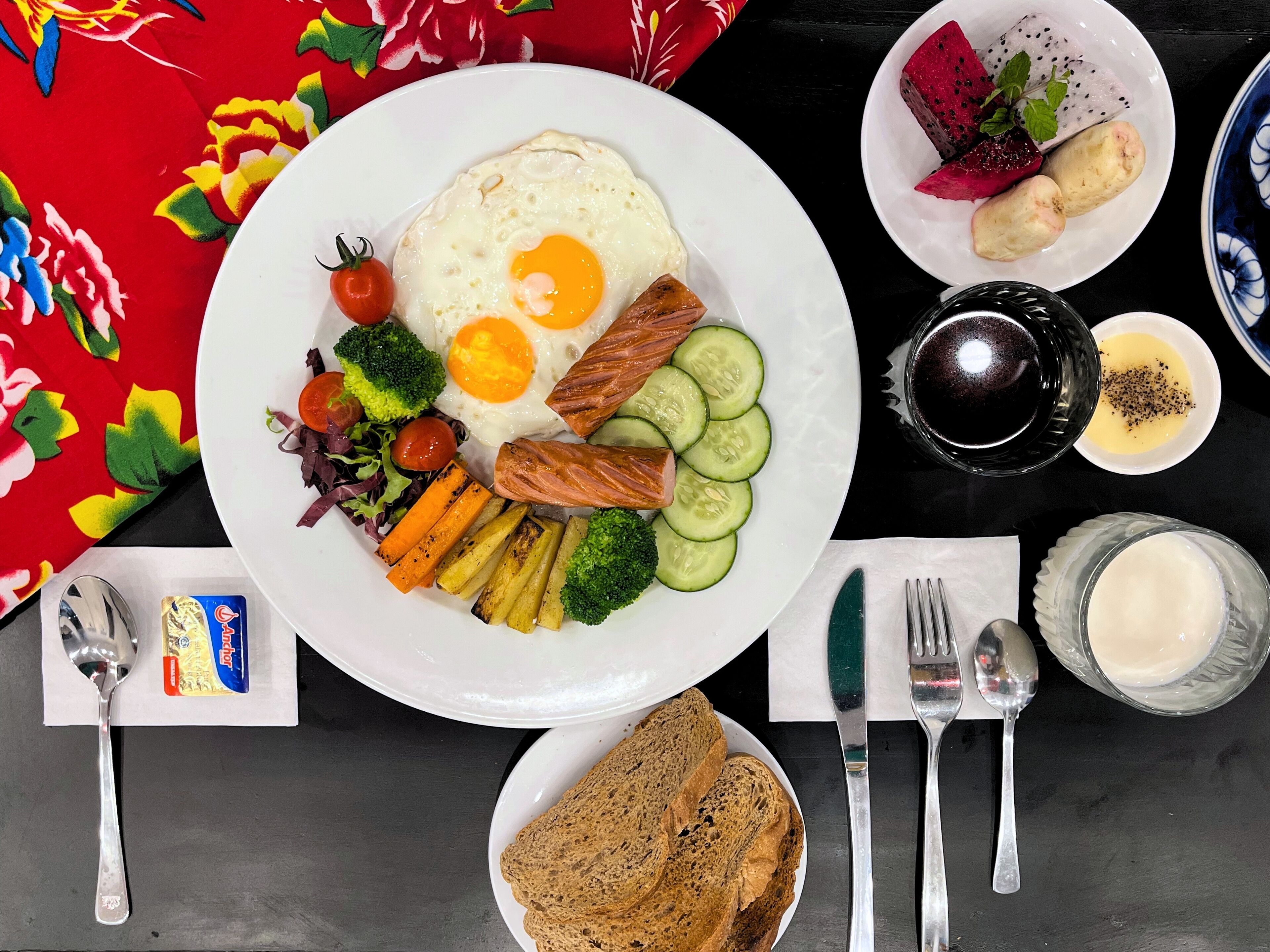 Prato de café da manhã com ovos, salmão, legumes e pão.
