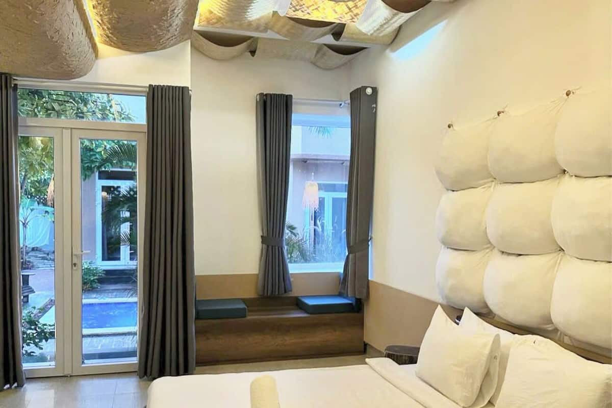 Quarto de hotel com uma cama grande, vista para o exterior e um design de teto exclusivo.