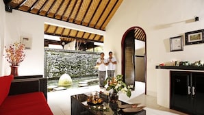 Um interior moderno com área de refeições, cozinha e vista para um espelho d'água.