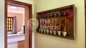 Um quarto com cama, janela com cortinas e uma obra de arte na parede com plantas em vasos e o texto 'the heros'.