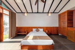 Quarto com uma cama grande, cabeceira de madeira e guarda-roupa.