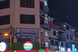 Um edifício com vários andares e sinalização comercial, incluindo uma cooperativa de crédito visível e um negócio chamado 'Impiat'.