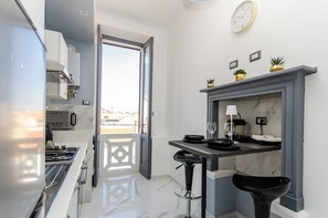 Apartamento, vista para o pátio | Cozinha privada | Um frigorífico/congelador grande, um micro-ondas, um forno 
