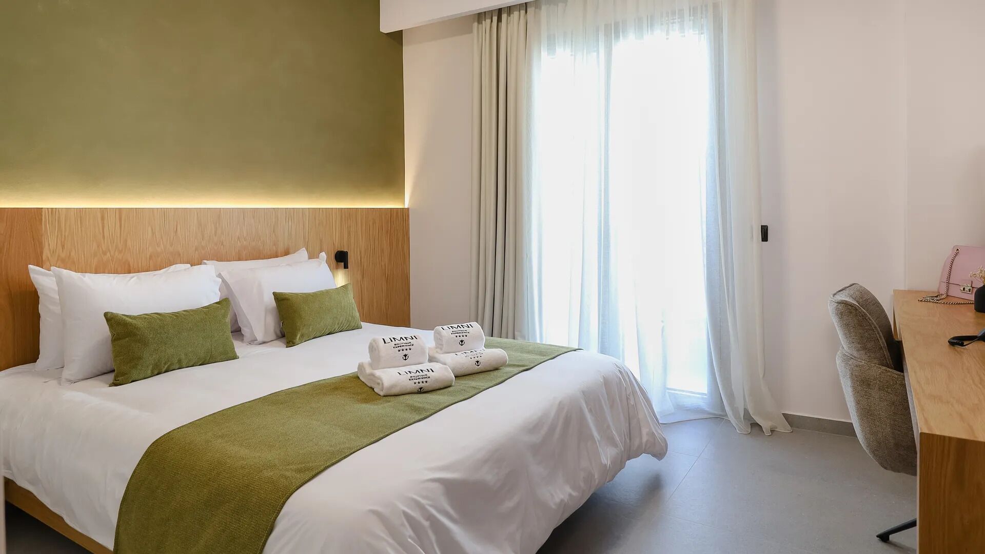 Quarto de hotel com uma cama, uma mesa e uma cadeira.