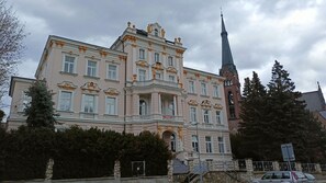 Um edifício histórico com detalhes arquitetônicos elaborados, uma torre imponente e uma placa indicando que é um prédio de apartamentos.