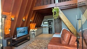 Um amplo loft com pé direito alto, varanda, cozinha e área de estar aconchegante.