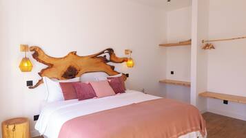 Quarto com cama grande, cabeceira de madeira e estantes embutidas.