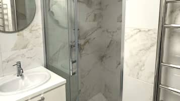 Apartamento Comfort, vista para o jardim | Casa de banho | Um polibã, artigos de higiene pessoal grátis, um secador de cabelo