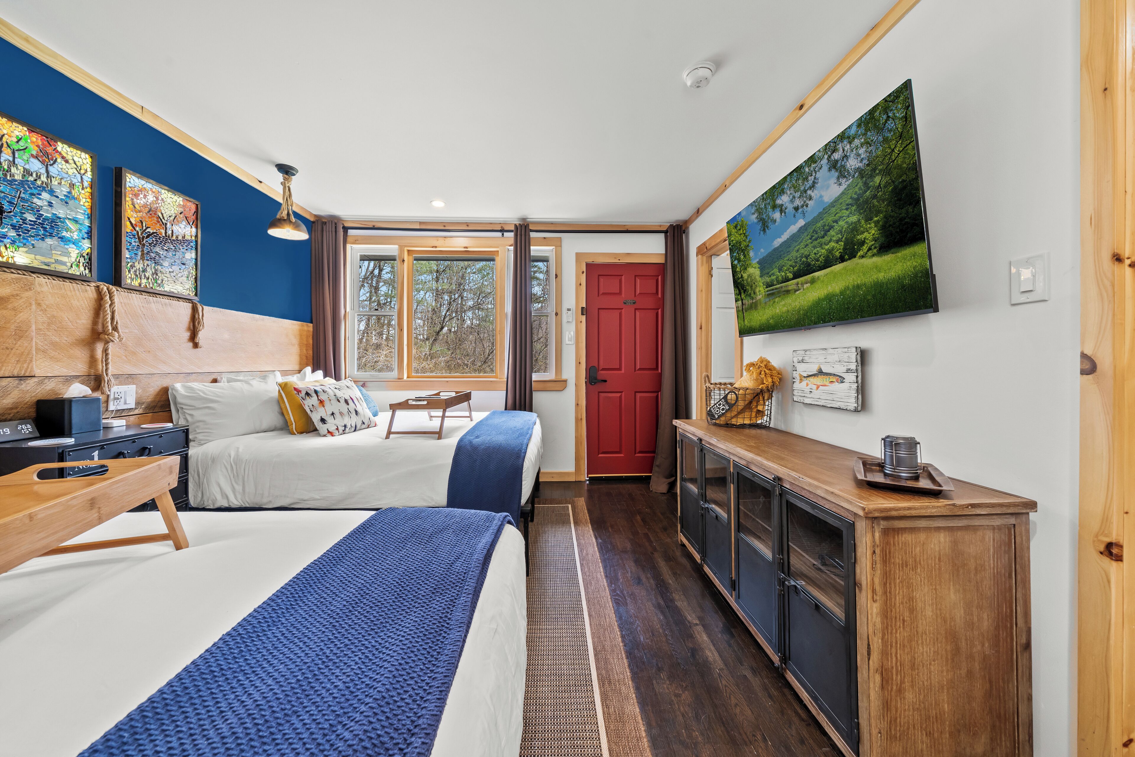 Quarto de hotel moderno com cama, mesa de cabeceira e uma janela grande.