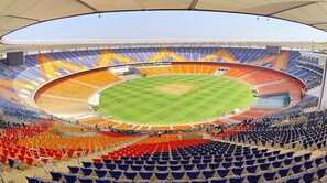 Um estádio com assentos em terraços e um campo central.