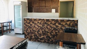 Cozinha compacta com backsplash estampado em padrão geométrico, geladeira branca e bancada de madeira.
