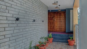 Paredes de tijolos com uma porta de madeira e plantas em vasos.