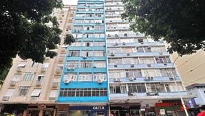 Um edifício com várias andares, varandas e aparelhos de ar condicionado.
