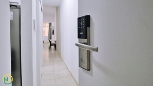Corredor com porta moderna e fechadura eletrônica com teclado digital.