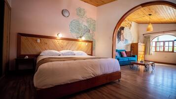 Um quarto espaçoso com uma cama grande, cabeceira de madeira e um mural floral exclusivo.