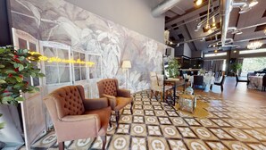 Um interior moderno com poltronas estofadas, piso estampado e um mural com placas que dizem 'GARDEN'.