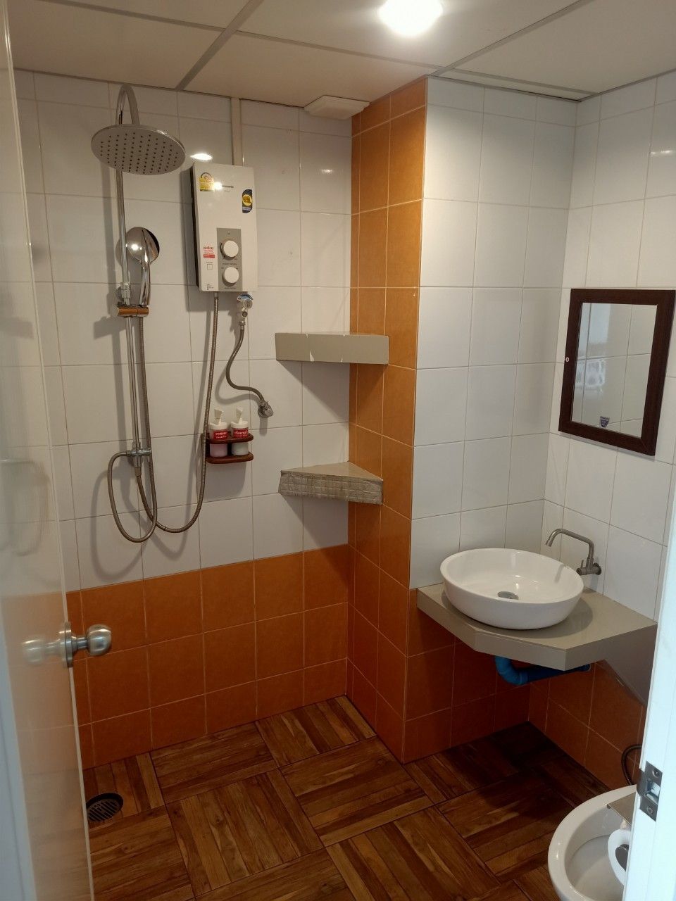 Um banheiro com chuveiro, pia e vaso sanitário.