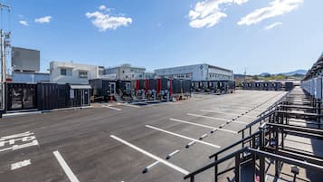 Um estacionamento com vagas demarcadas e um edifício ao fundo.
