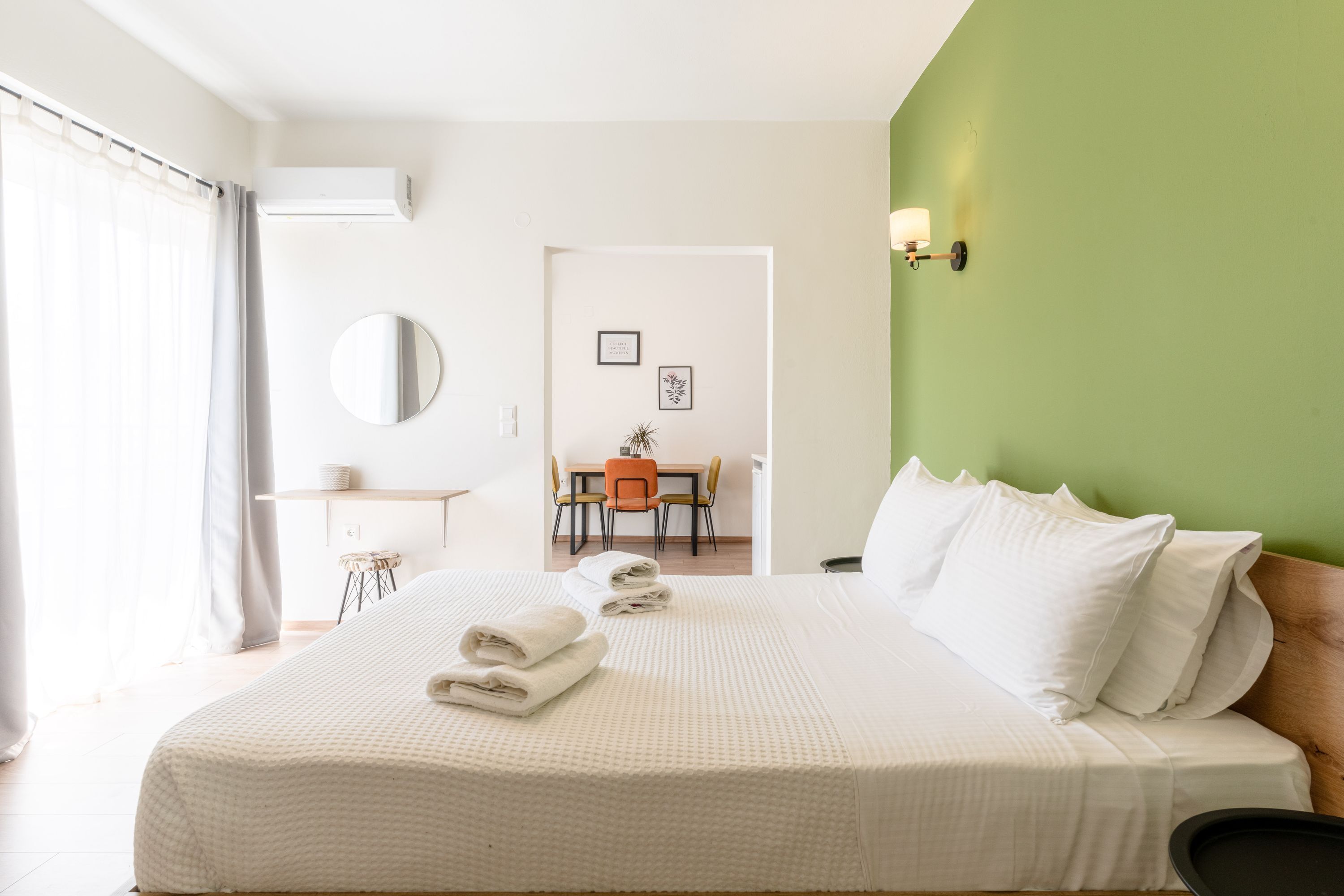 Quarto de hotel com uma cama grande, uma escrivaninha e uma cadeira.