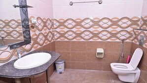 Uma casa de banho com lavatório, sanita e chuveiro.