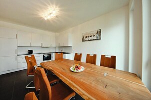 Uma sala de jantar moderna com uma mesa de madeira, seis cadeiras e um prato de comida.
