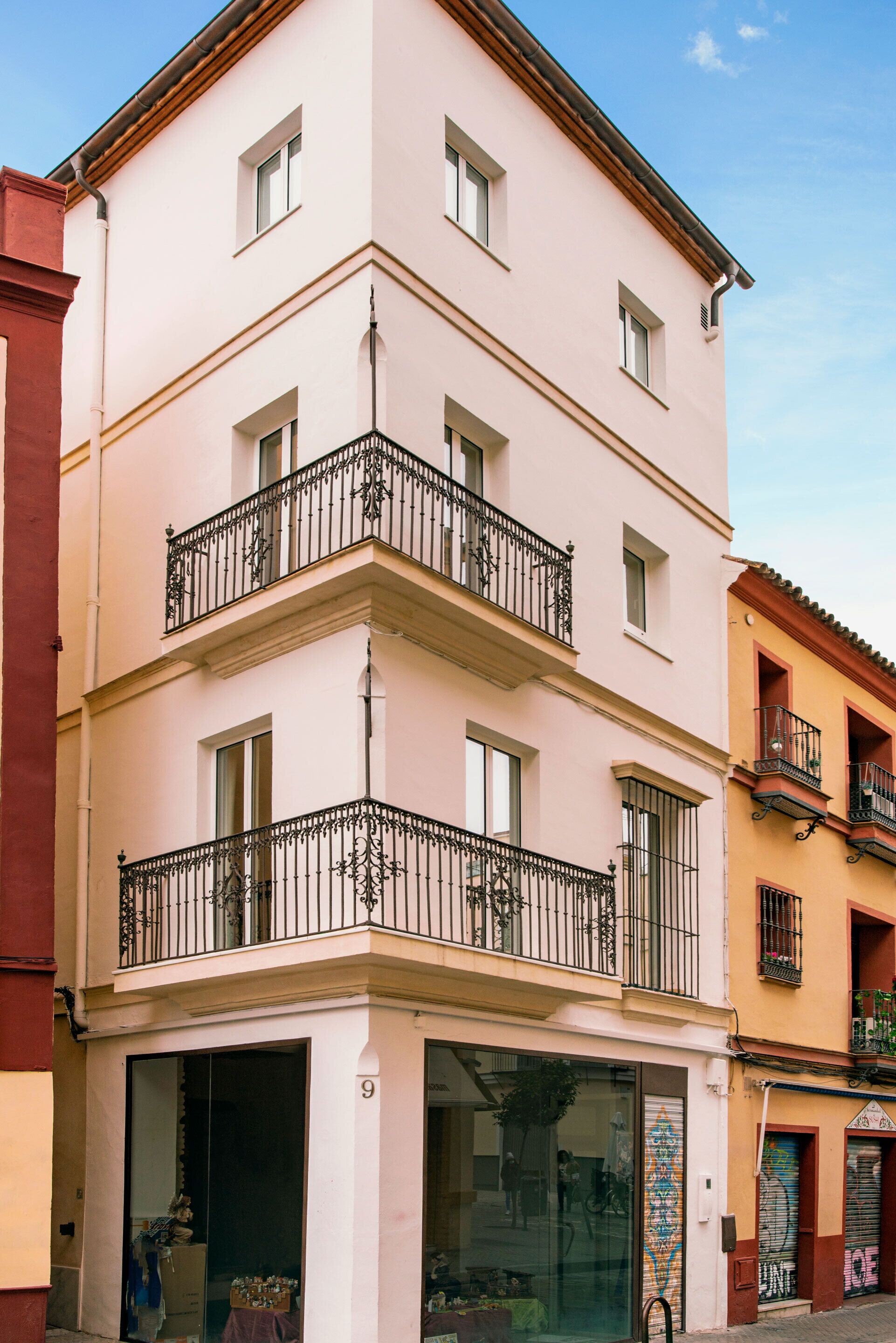 Um edifício com várias andares, varandas e janelas amplas.