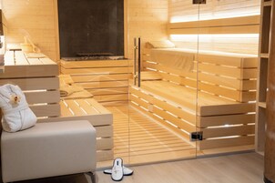 Um spa moderno com bancos de madeira, mesa de massagem e divisória de vidro.