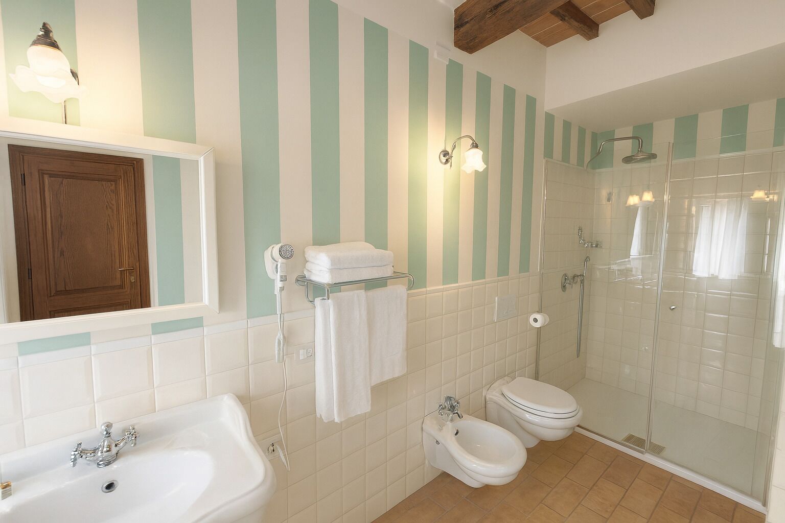 Casa de banho com banheira, dois bidés, sanita e cabine de duche.