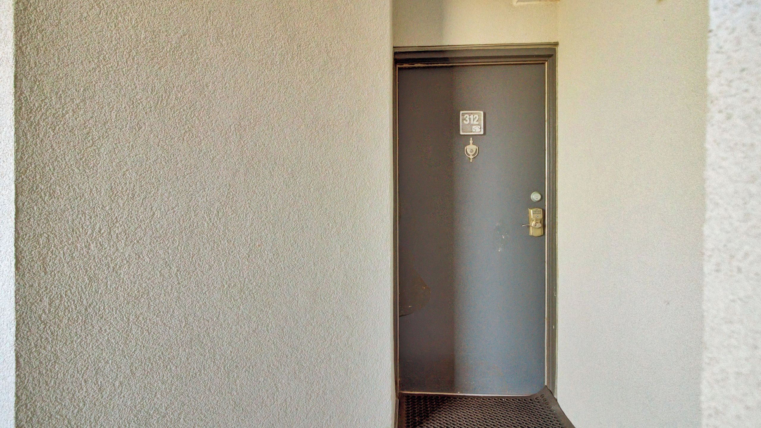 Uma porta com placa de identificação, fechadura e campainha.