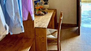 Uma mesa de madeira com prato de comida e bebidas, uma decoração de cacto e uma placa com a inscrição "IRVINE HOTEL".