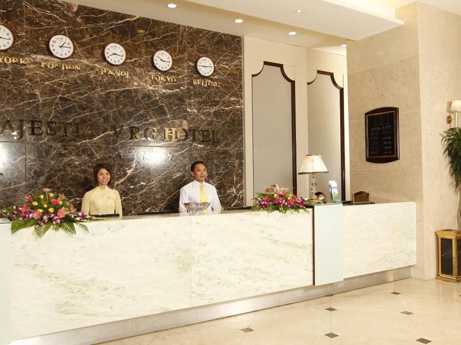 Bancada de recepção de hotel com relógios exibindo os horários de Nova York, Londres, Paris, Tóquio e Pequim.