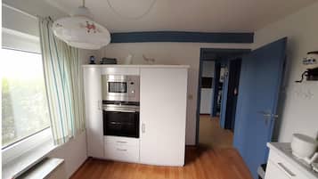 Uma cozinha compacta com forno embutido, micro-ondas e um pequeno balcão.